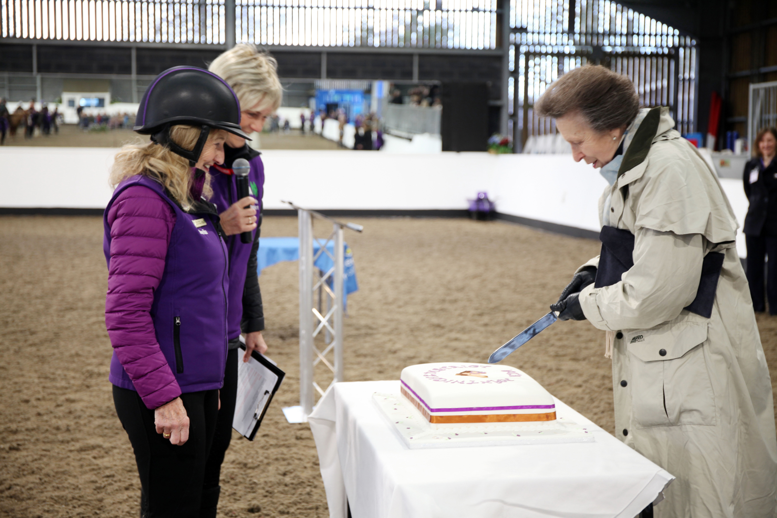 The Princess Royal cuts a cake, watched by Sheila Saner and Eleanor Dixon - Reaseheath College